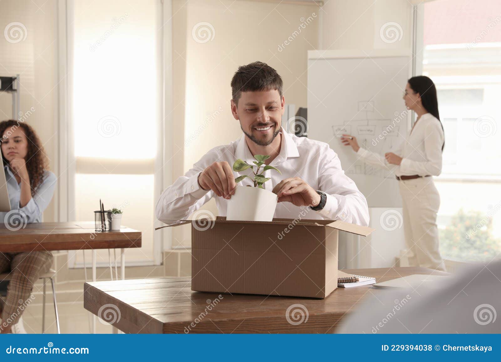 New Coworker Unpacking Box with Personal Items at Workplace in Office ...