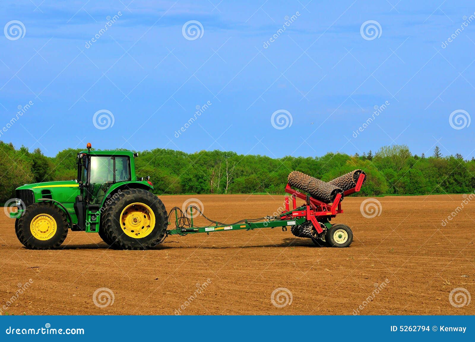 A Farm Tractor Is Shown Behind A Combiner Trailer In A Field Editorial ...