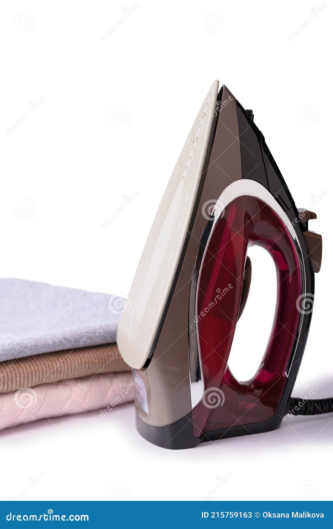 A New Iron for Ironing Clothes Stands with a Stack of Laundry Lying ...