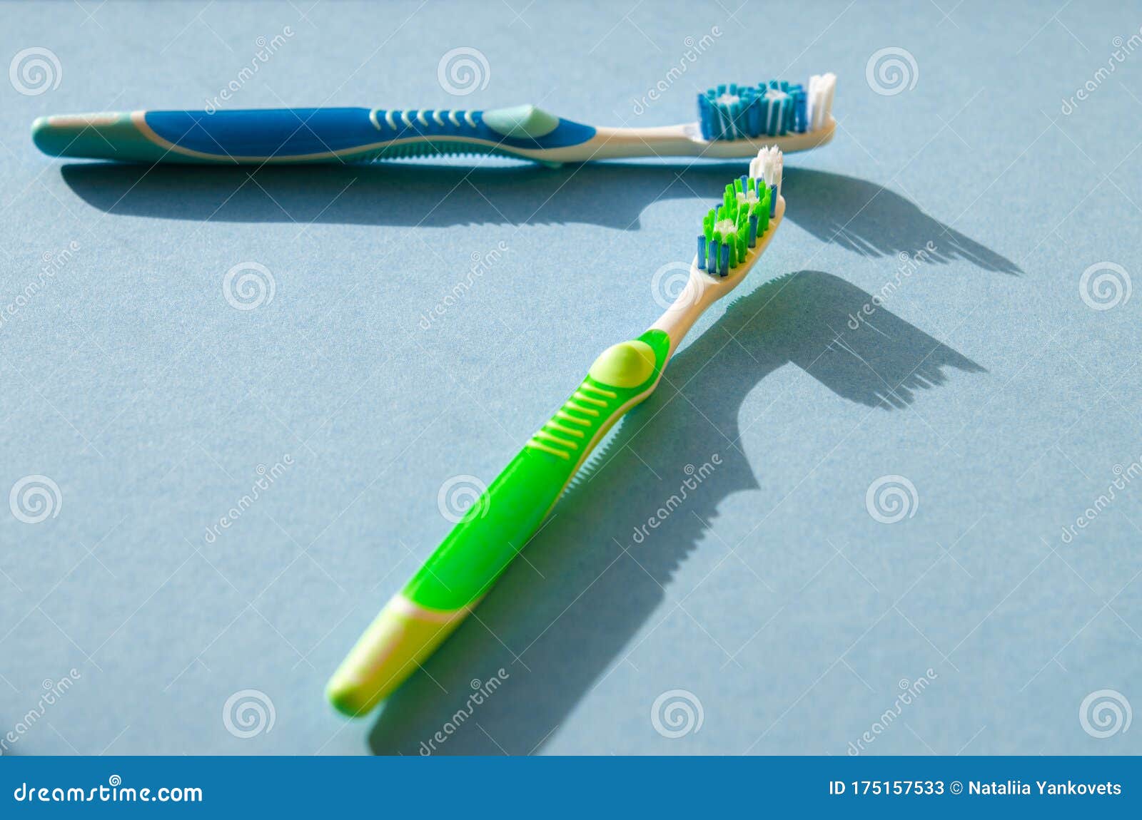 New Multicolored Toothbrushes with Sharp Shadows Lie on a Blue ...
