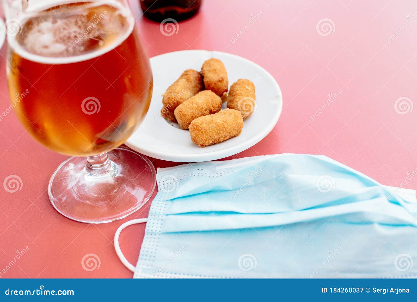 Glass of Beer and a Plate of Tapas with a Mask on the Table Stock Image ...