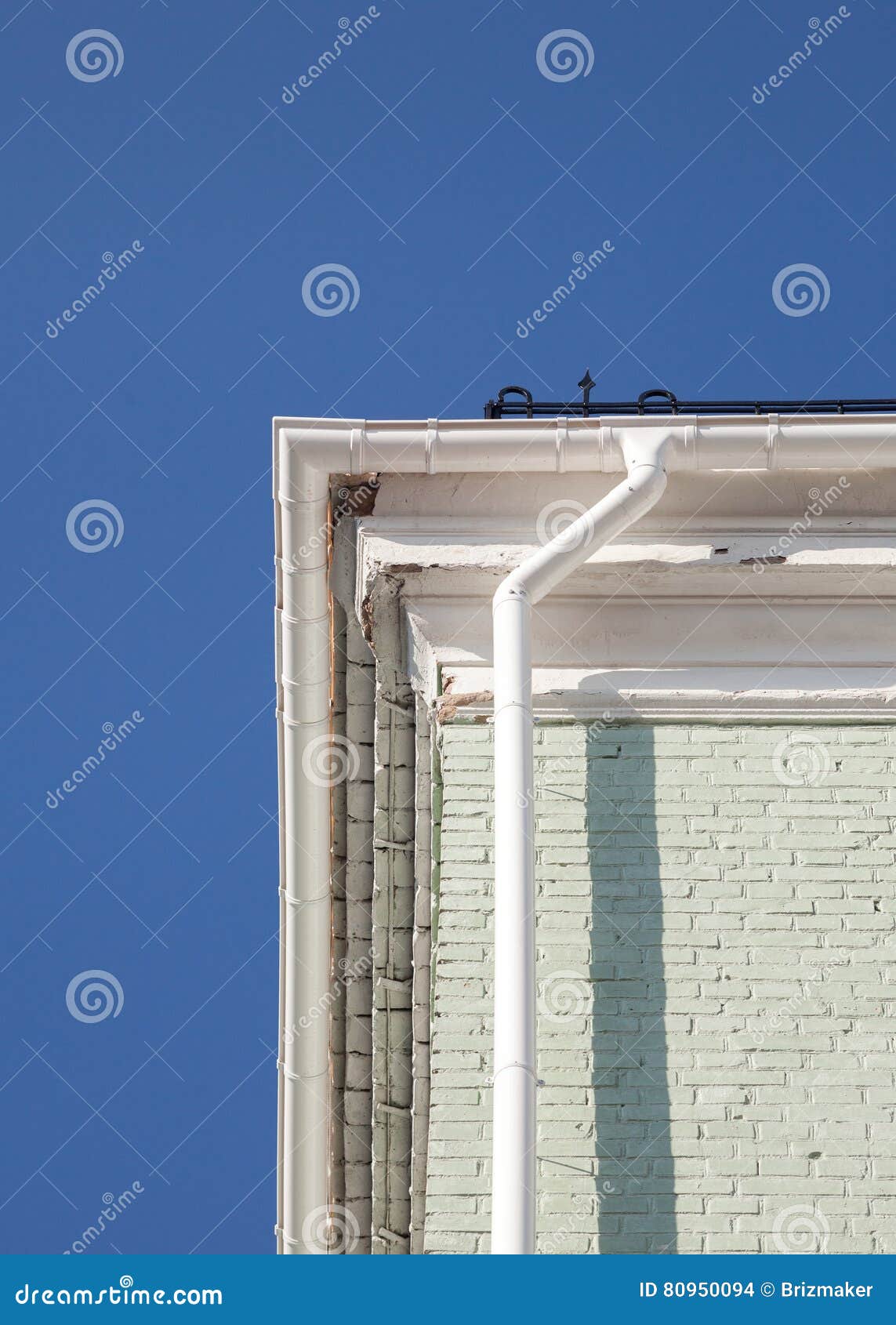 New Rain Gutter on a Brick Wall Against Blue Sky. Stock Photo - Image ...