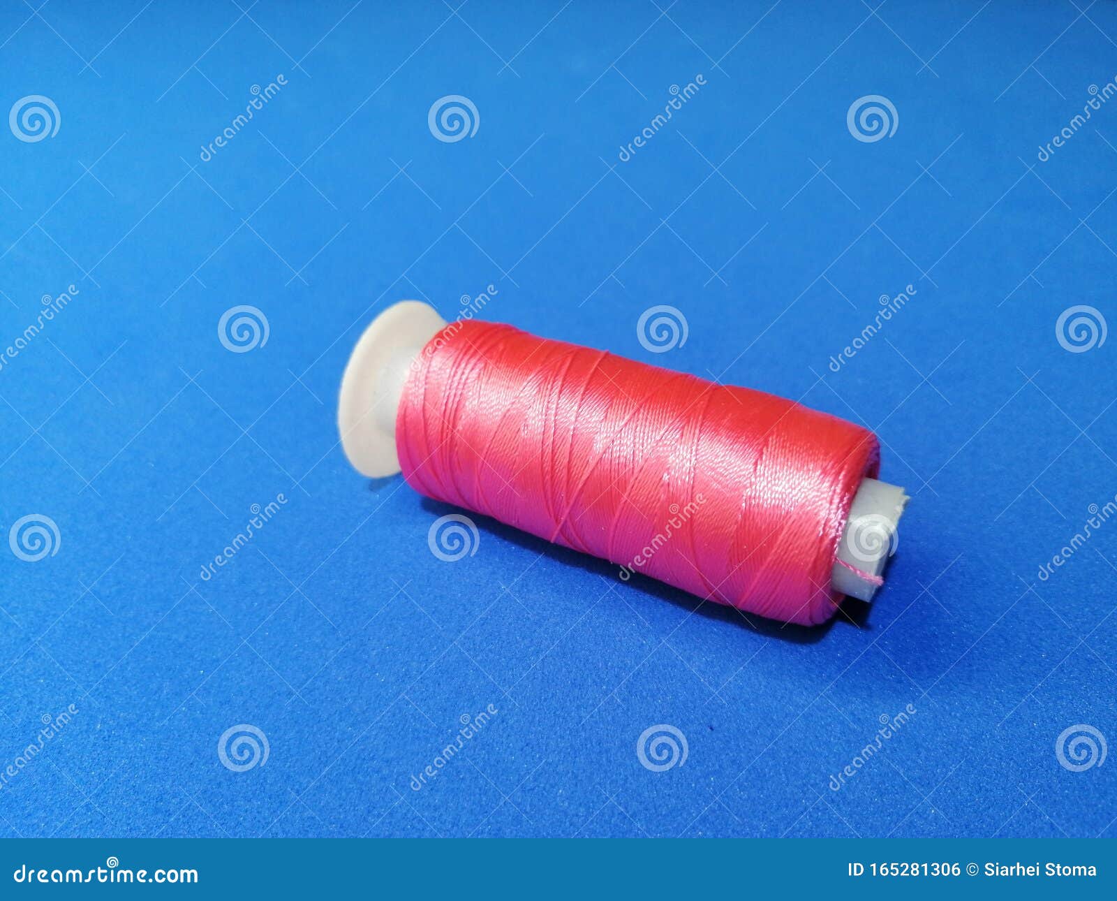 Spool of Silk Pink Thread on a Blue Background Stock Photo - Image of ...