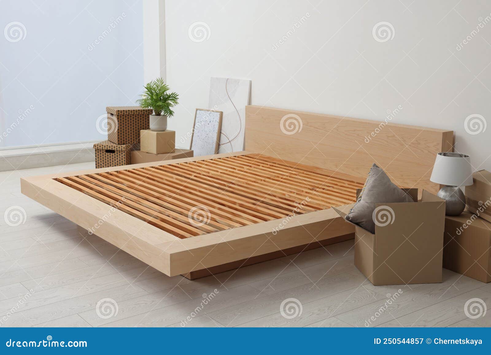 New Wooden Bed Frame, Moving Boxes and Decor Elements Indoors Stock ...