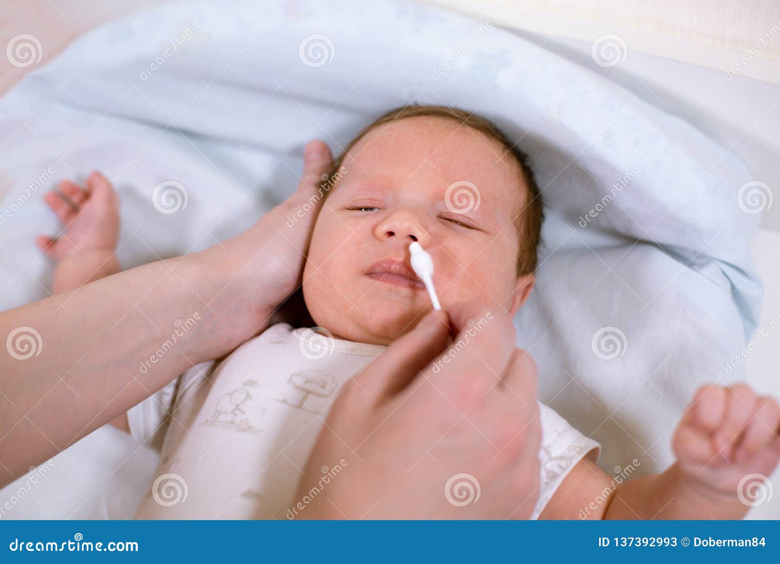 Newborn Hygiene. Mother Cleaning Baby Nose with Cotton Swab, Closeup ... Newborn Hygiene. Mother Cleaning Baby Nose with Cotton Swab, Closeup ...