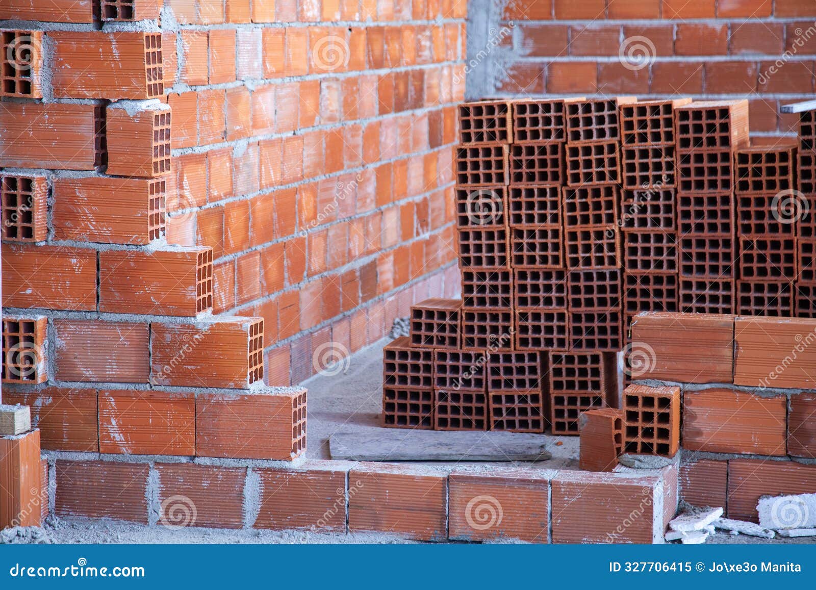 A Newly Built Brick Wall Stands Sturdy, with a Stack of Unused Bricks ...