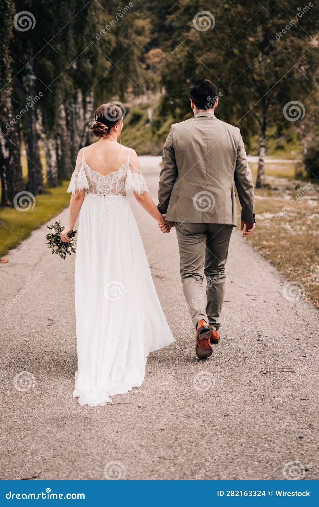 Newlyweds Strolling Hand in Hand Down a Scenic Path in the Park. Stock ...