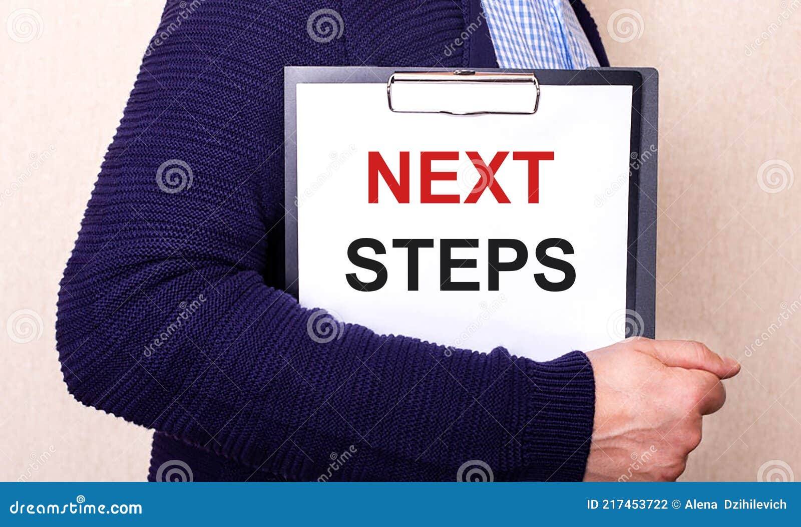 NEXT STEPS is Written on a White Sheet Held by a Man Standing Sideways ...