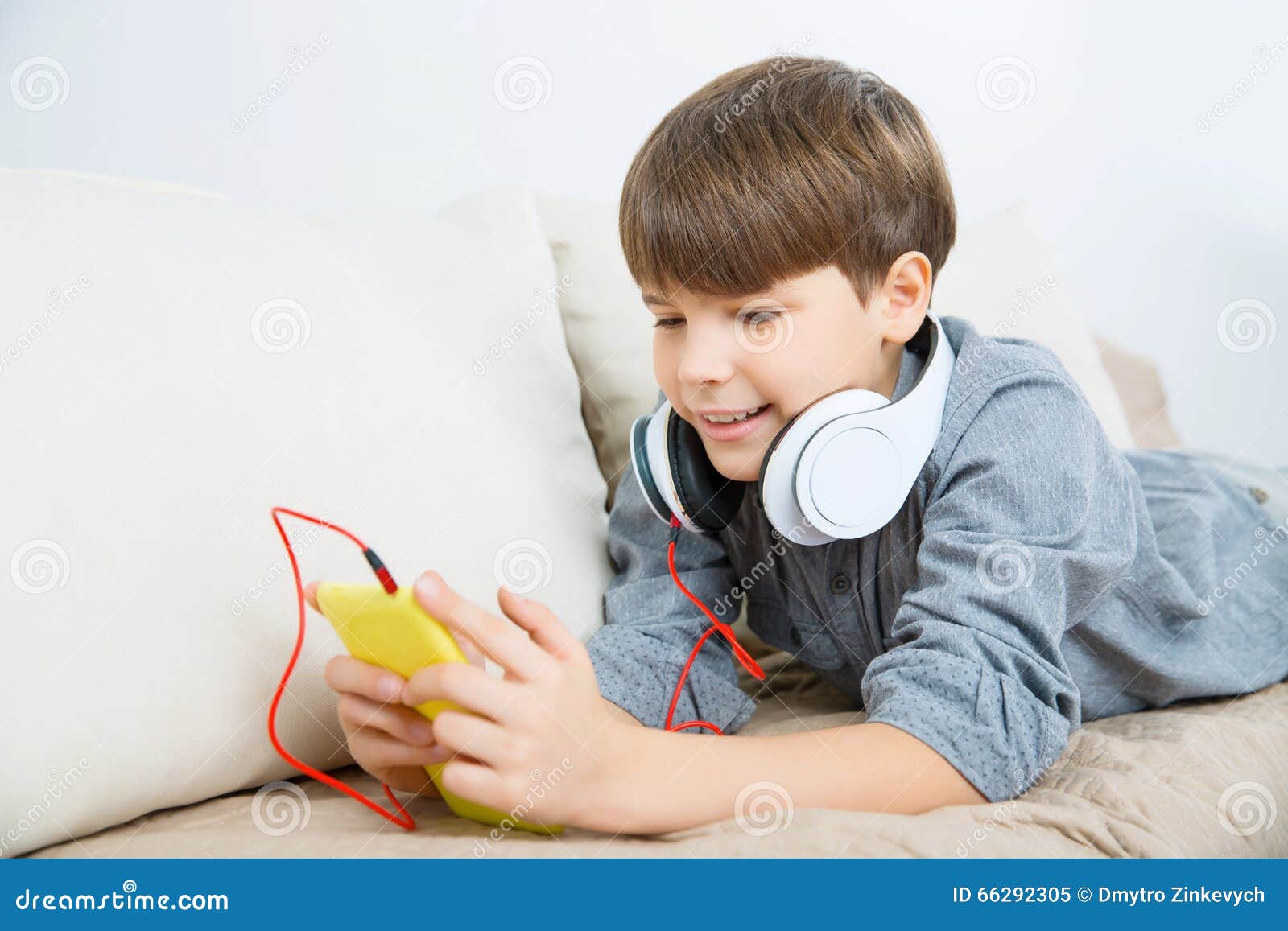 Nice Boy Relaxing on the Sofa with Phone and Headset. Stock Image ...