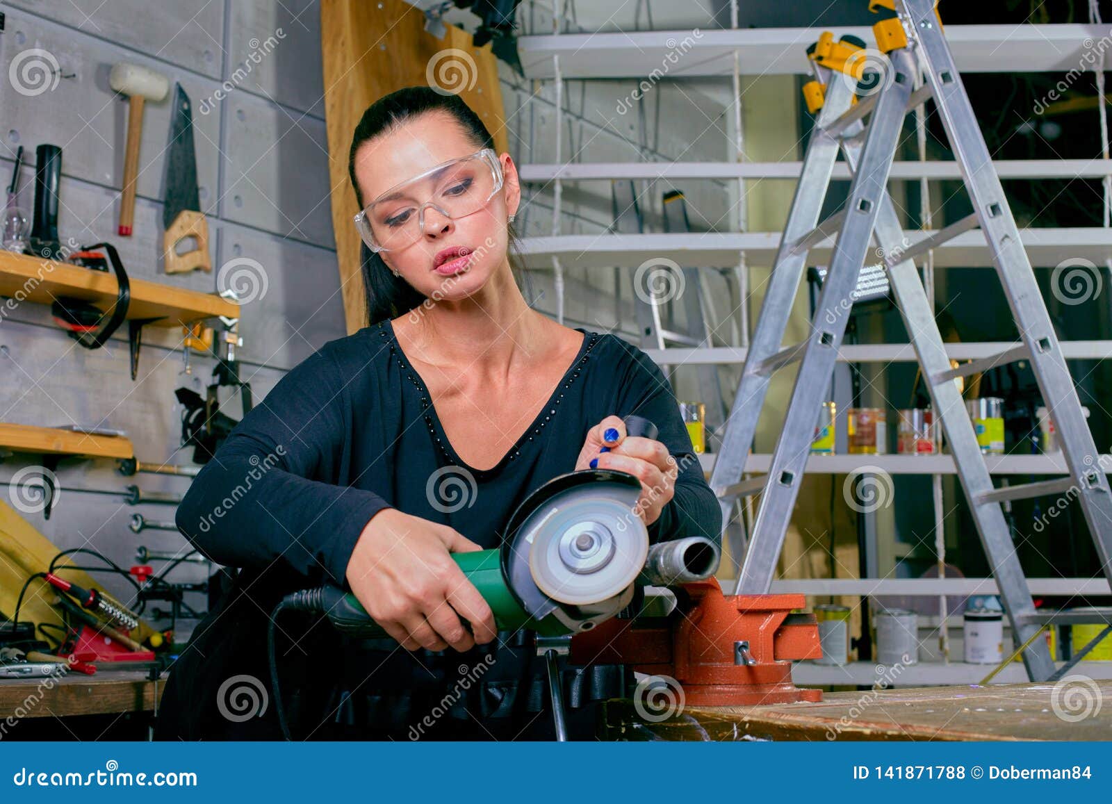 A Nice Caucasian Girl with Angle Grinder in Workshop with Bright Light ...
