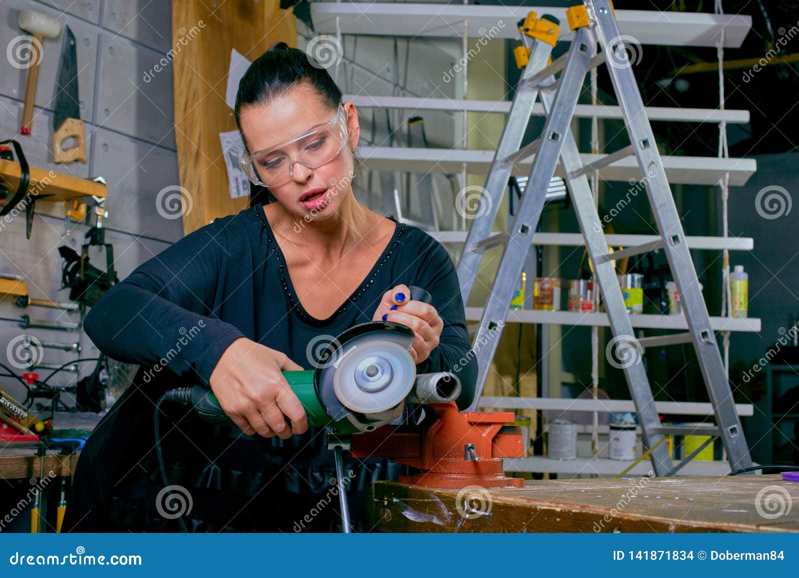 A Nice Caucasian Girl with Angle Grinder in Workshop with Bright Light ...