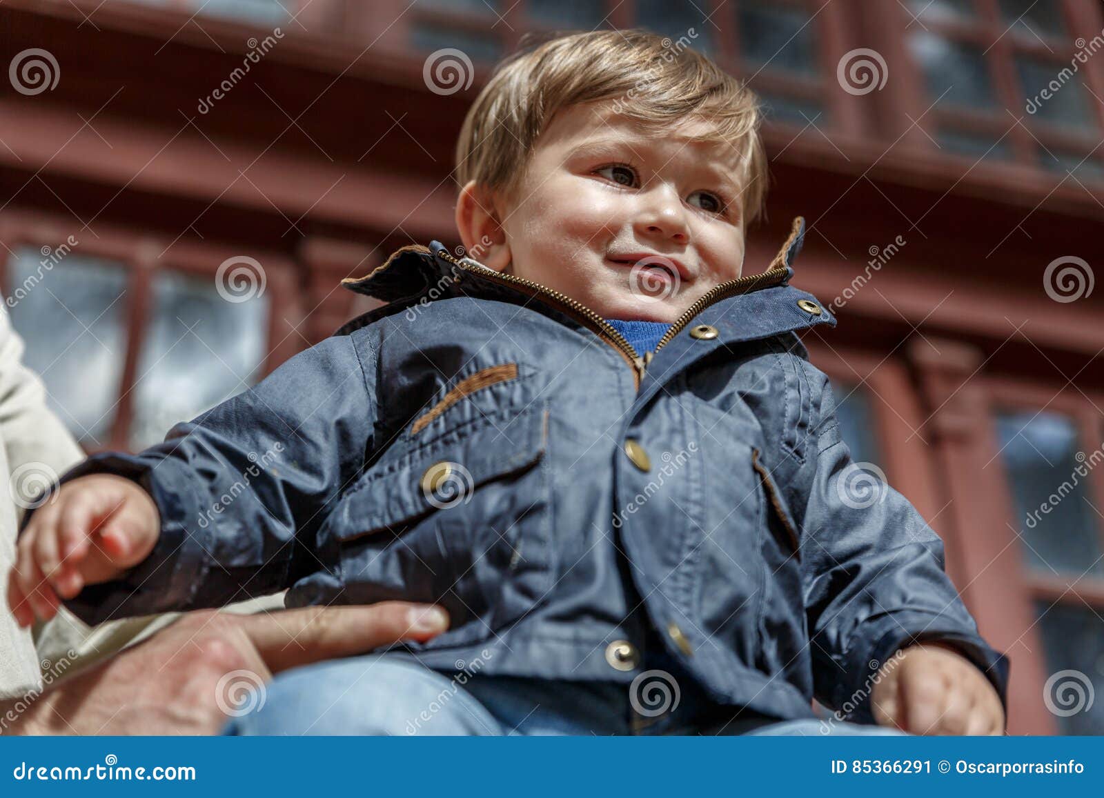 A Nice Child Looks Ahead while Being Held by an Adult Stock Image ...