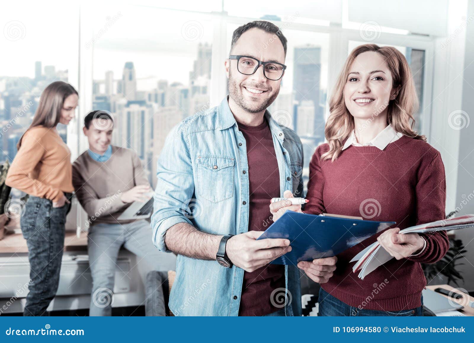 Nice-looking Satisfied Workers Holding Documents and Smiling. Stock ...