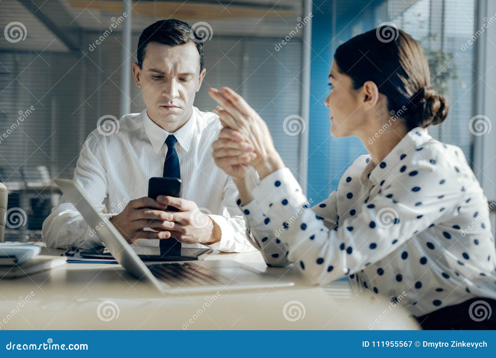 Nice Man Checking Phone while Discussing Work with Colleague Stock ...