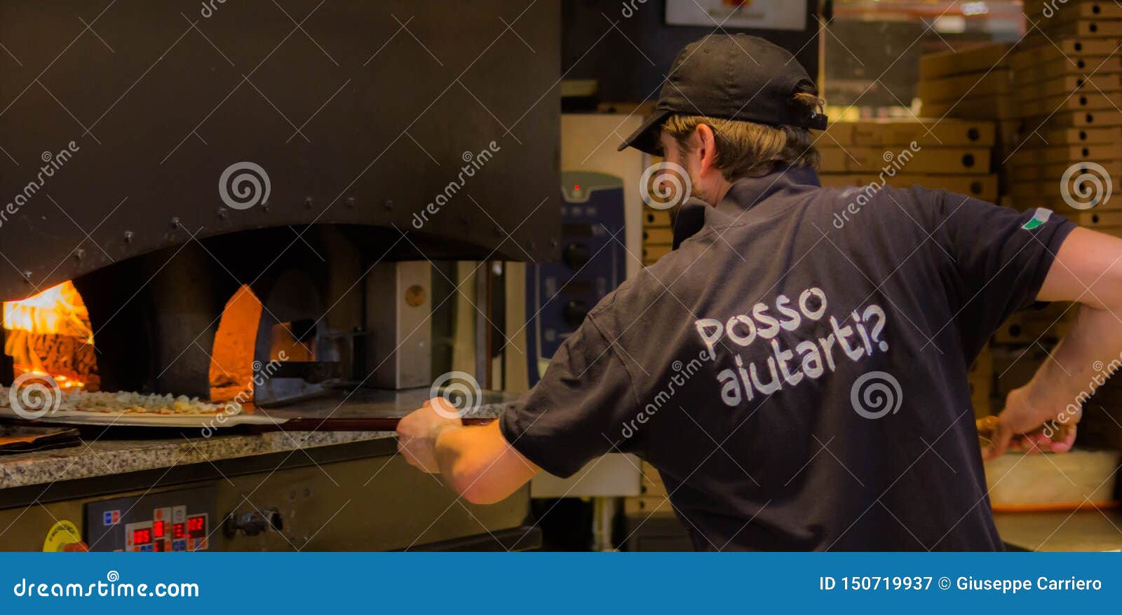 A Nice Pizza Maker while Working with the Oven Inserting One of His ...