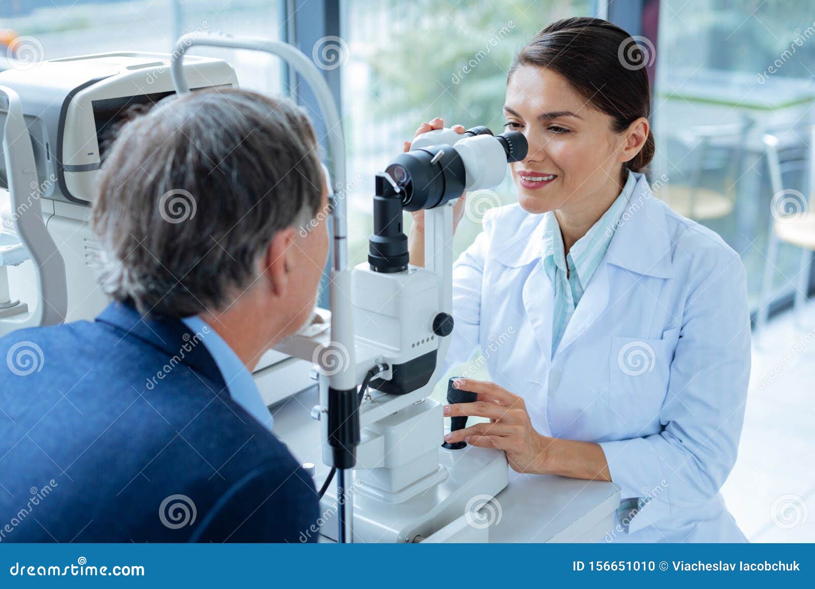 Nice Positive Optician Looking into the Microscope Stock Photo - Image ...