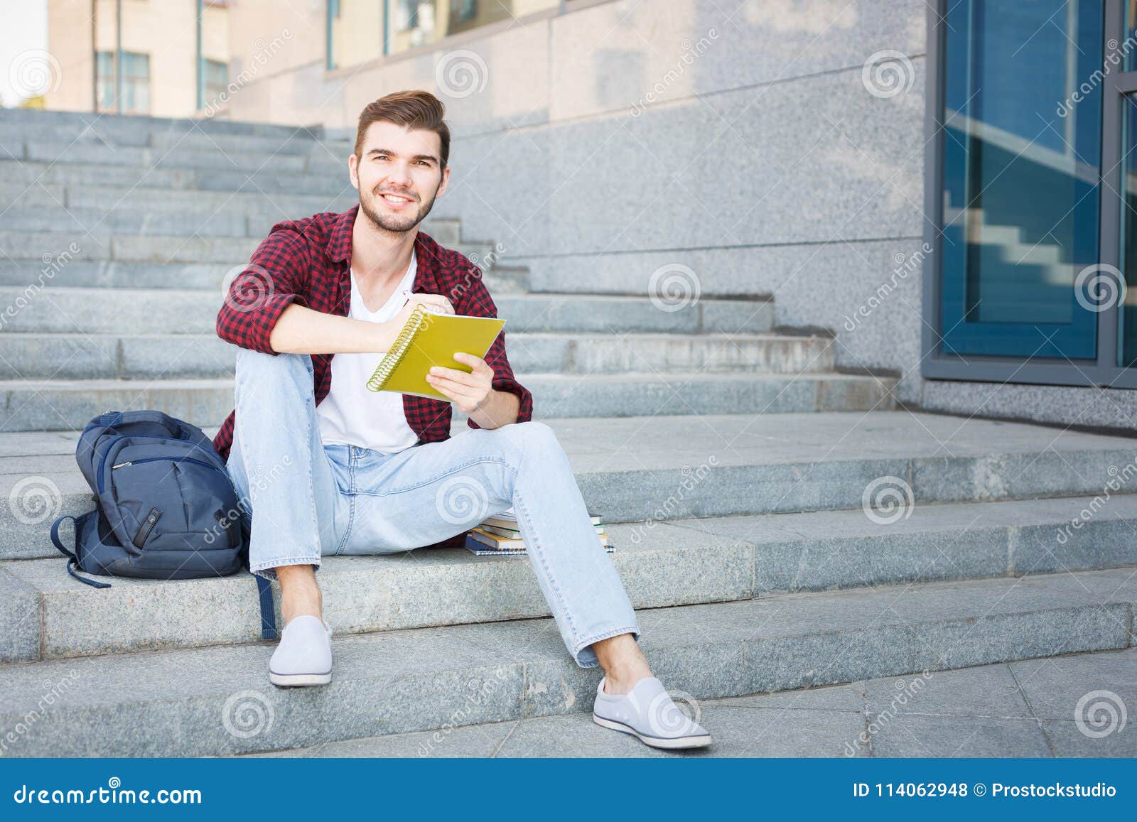 Nice Student Sitting on the Stairs and Writing Notes Outdoors Stock ...