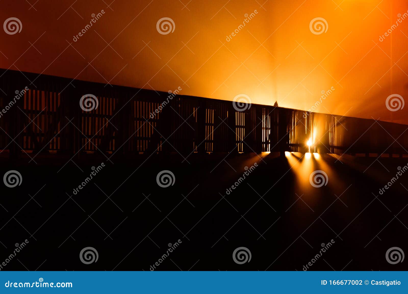 At Night, a Passing Car Crosses the Bridge Railing with Lights Stock ...