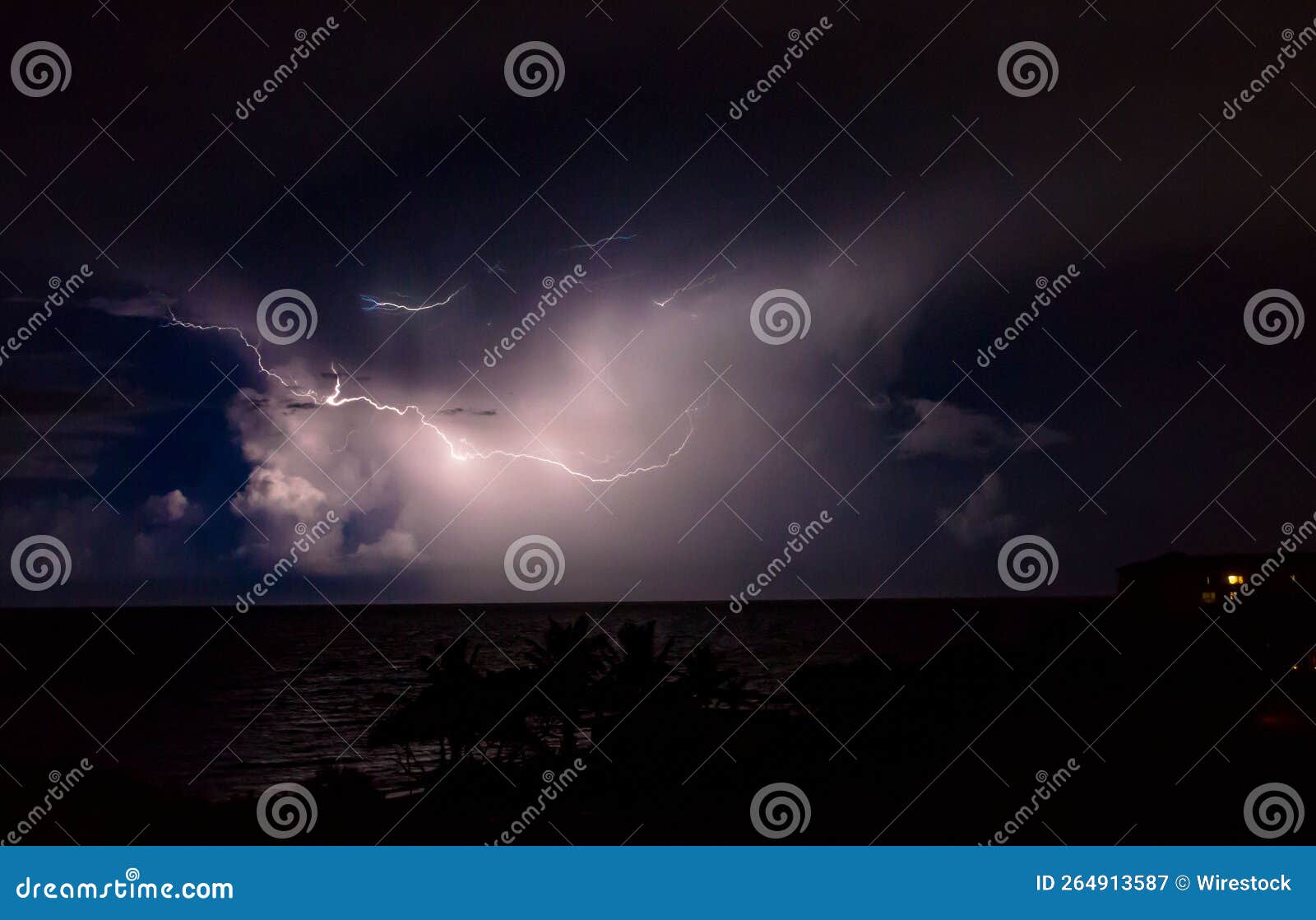 Night View of an Ocean Under the Mesmerizing Purple Sky with Lightning ...