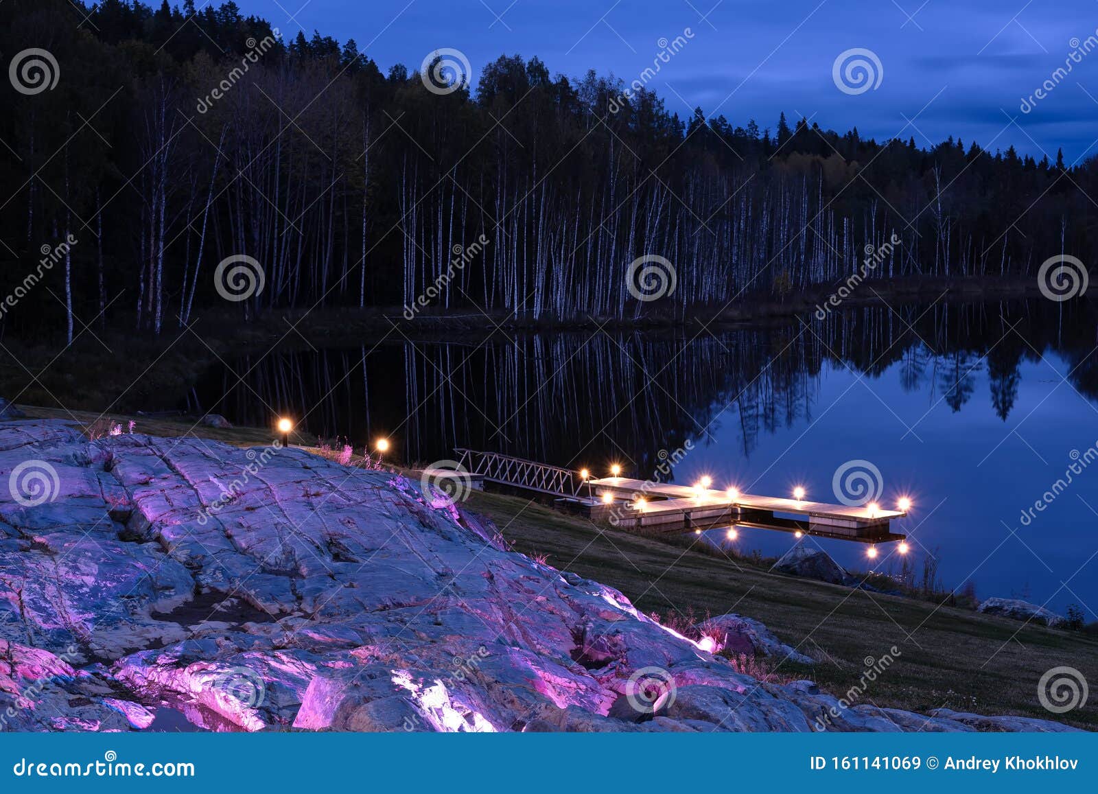 Night View of a Quiet Lake and Pier Illuminated by Garden Lights Stock ...