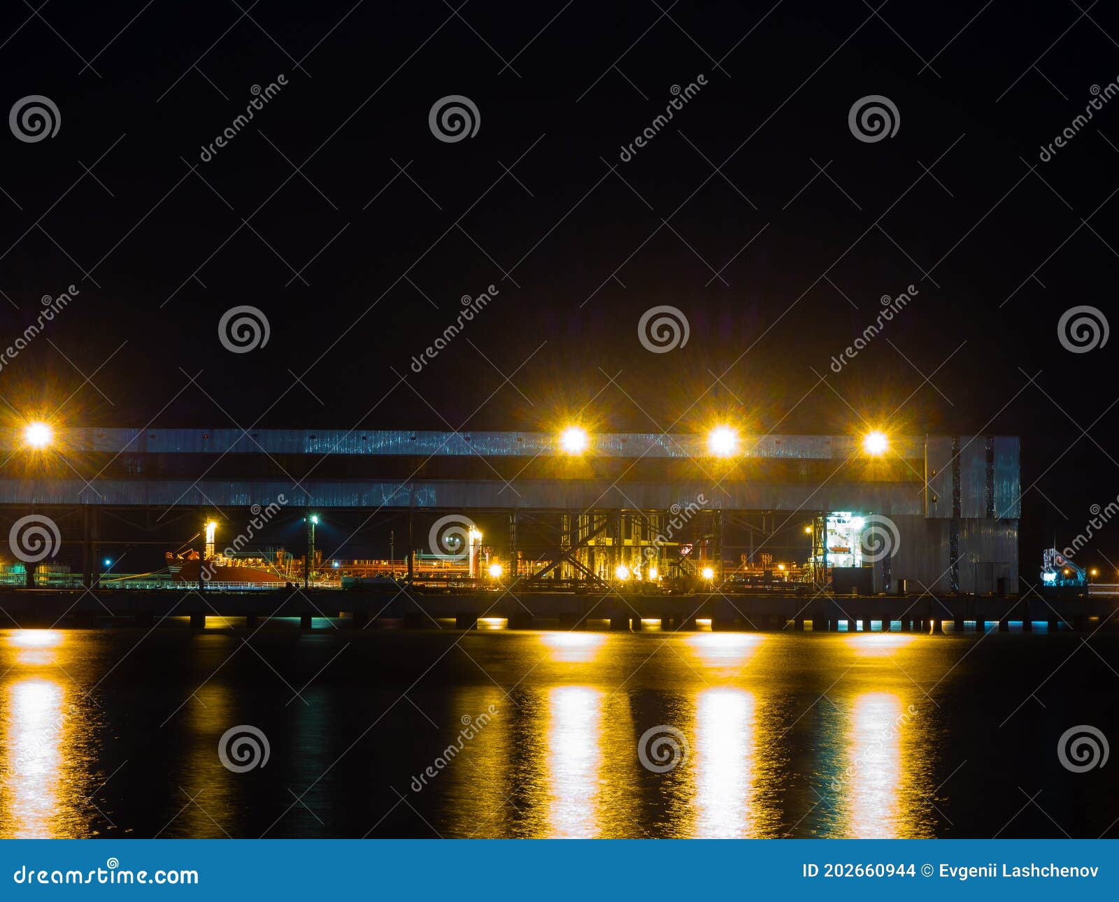 Night View of a Seaport with a Metal Structure Illuminated by Bright ...