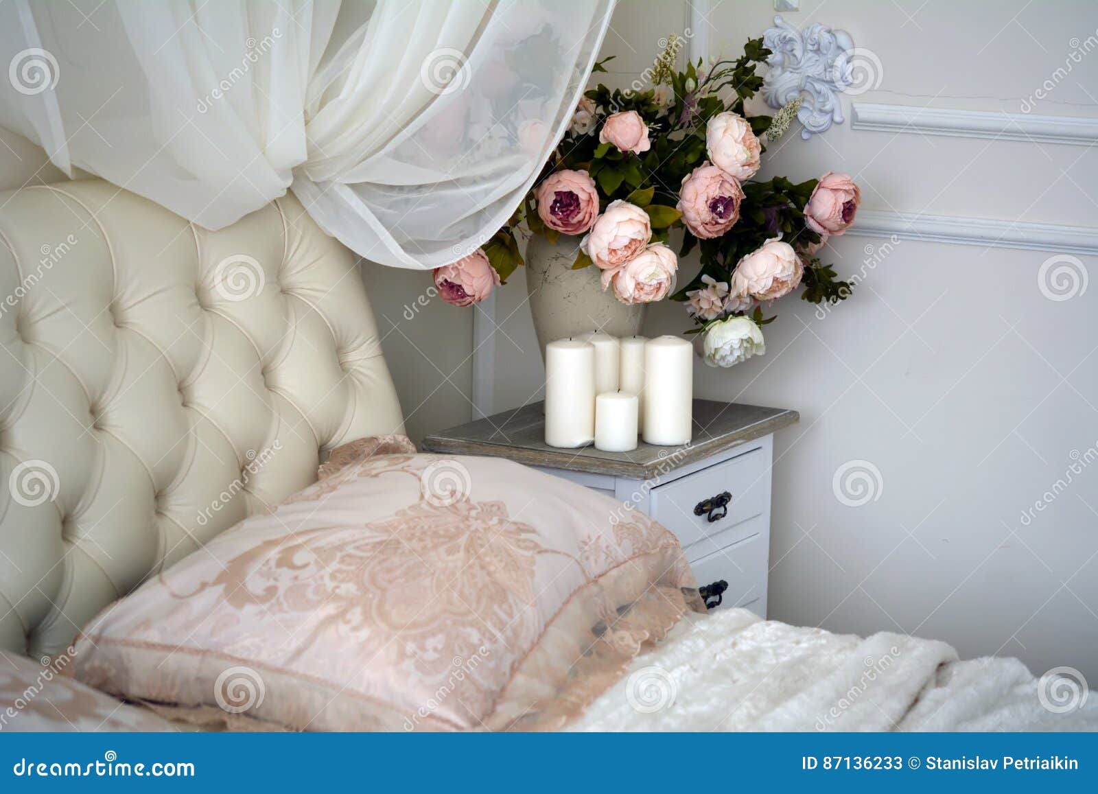 On the Nightstand beside the Bed is a Vase with Flowers and Candles ...