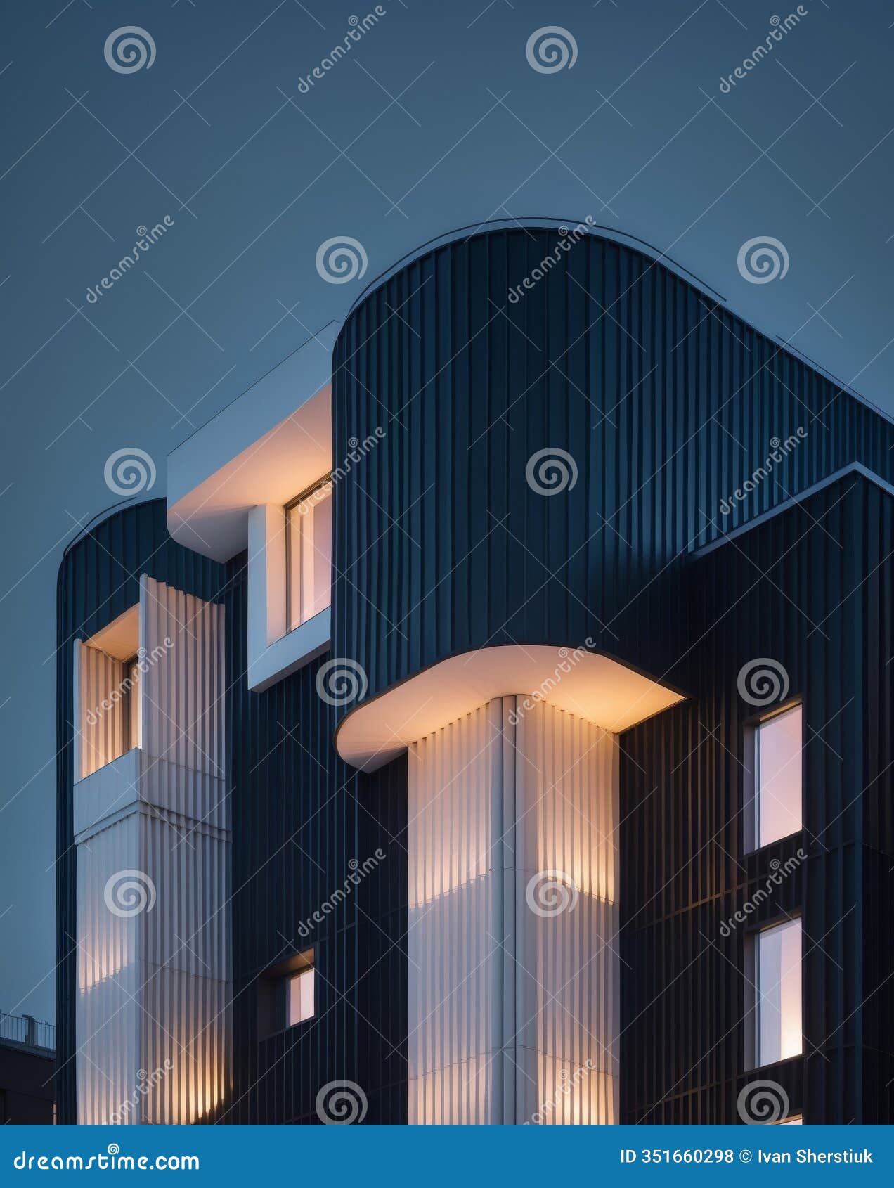 A Nighttime View of a Modern Building Facade with Rounded and ...