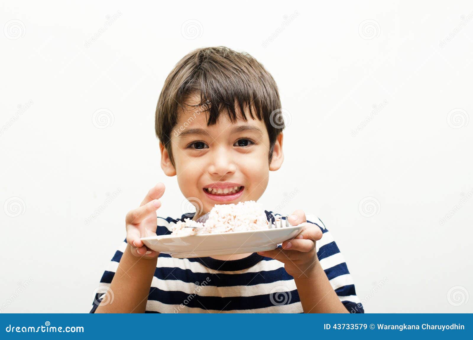 Niño Pequeño Que Come La Cara Feliz Del Arroz Imagen De Archivo
