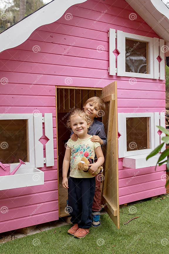Niños Jugando En Una Casa De Madera Rosa Para Niños En El Patio Trasero Foto De Archivo Imagen
