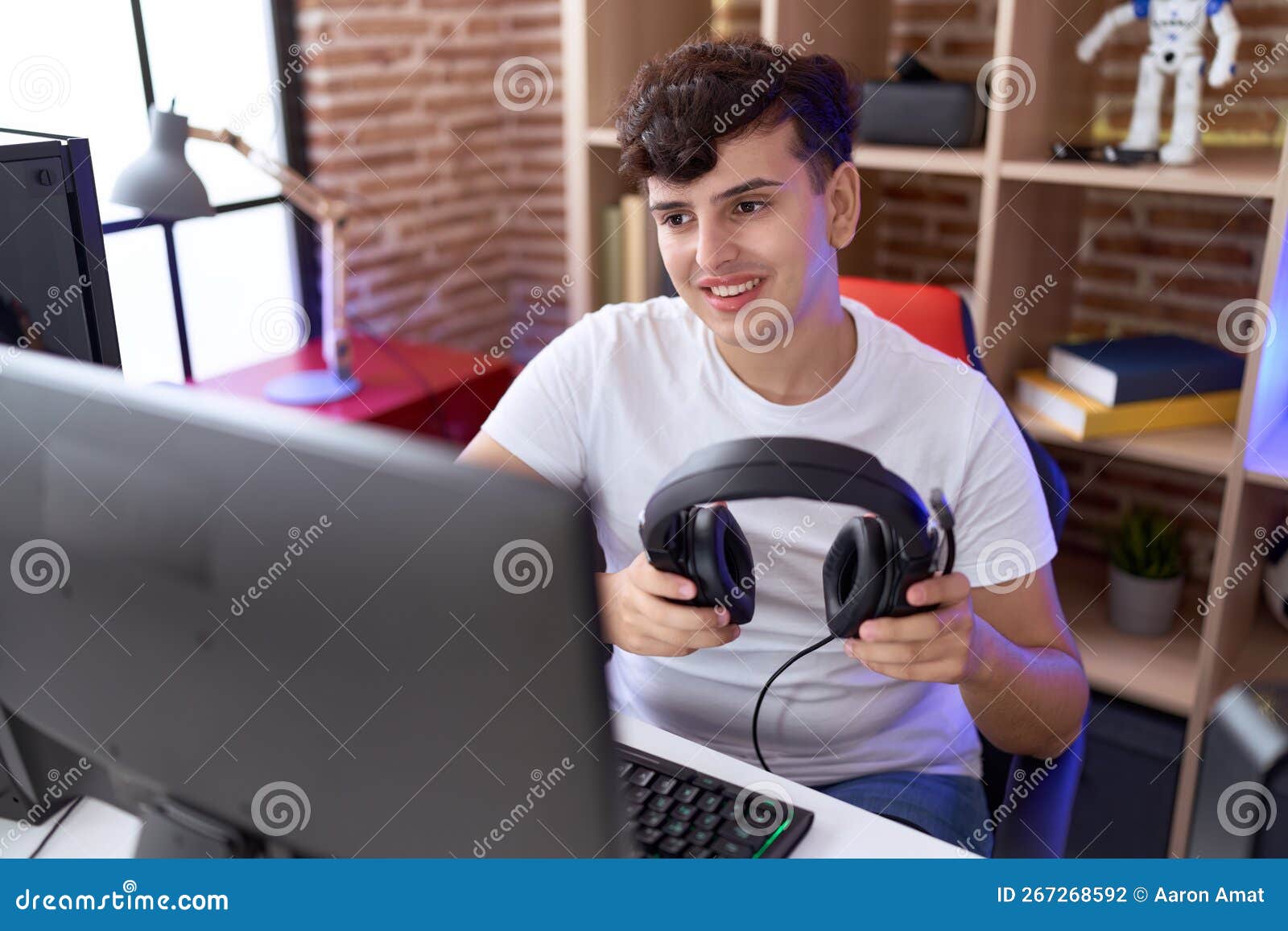 Non Binary Man Streamer Sitting on Table Holding Headphones at Gaming ...