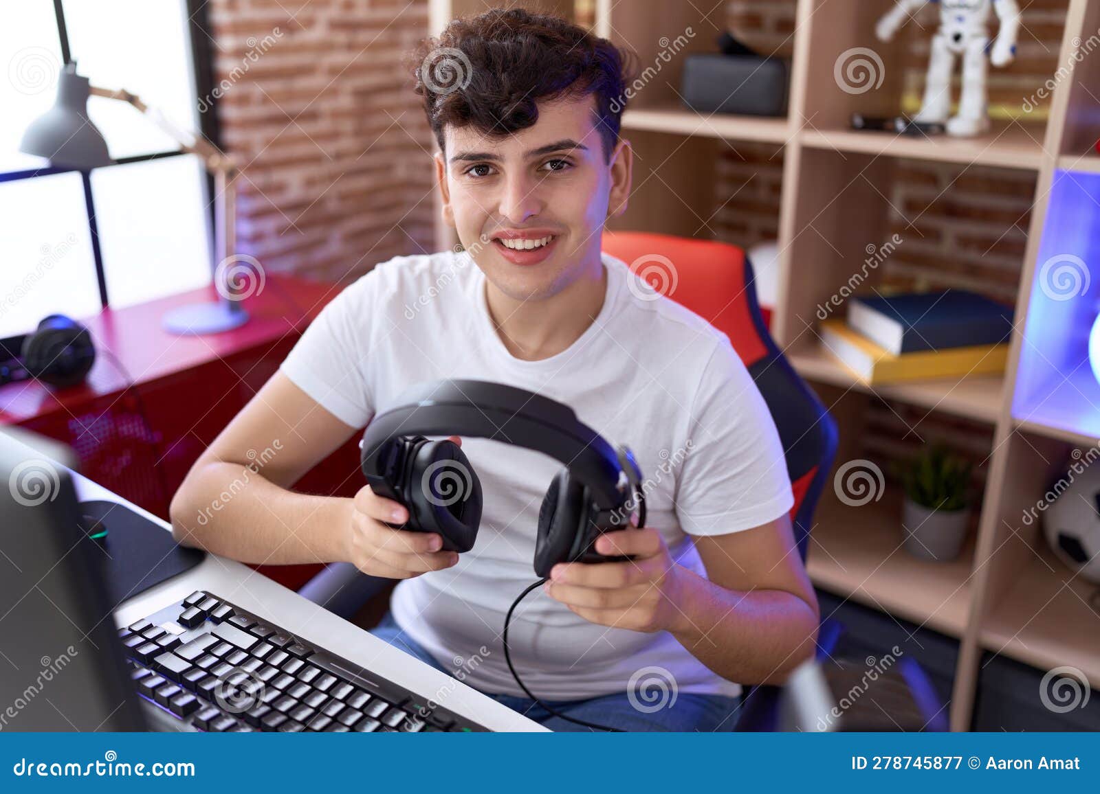 Non Binary Man Streamer Sitting on Table Holding Headphones at Gaming ...