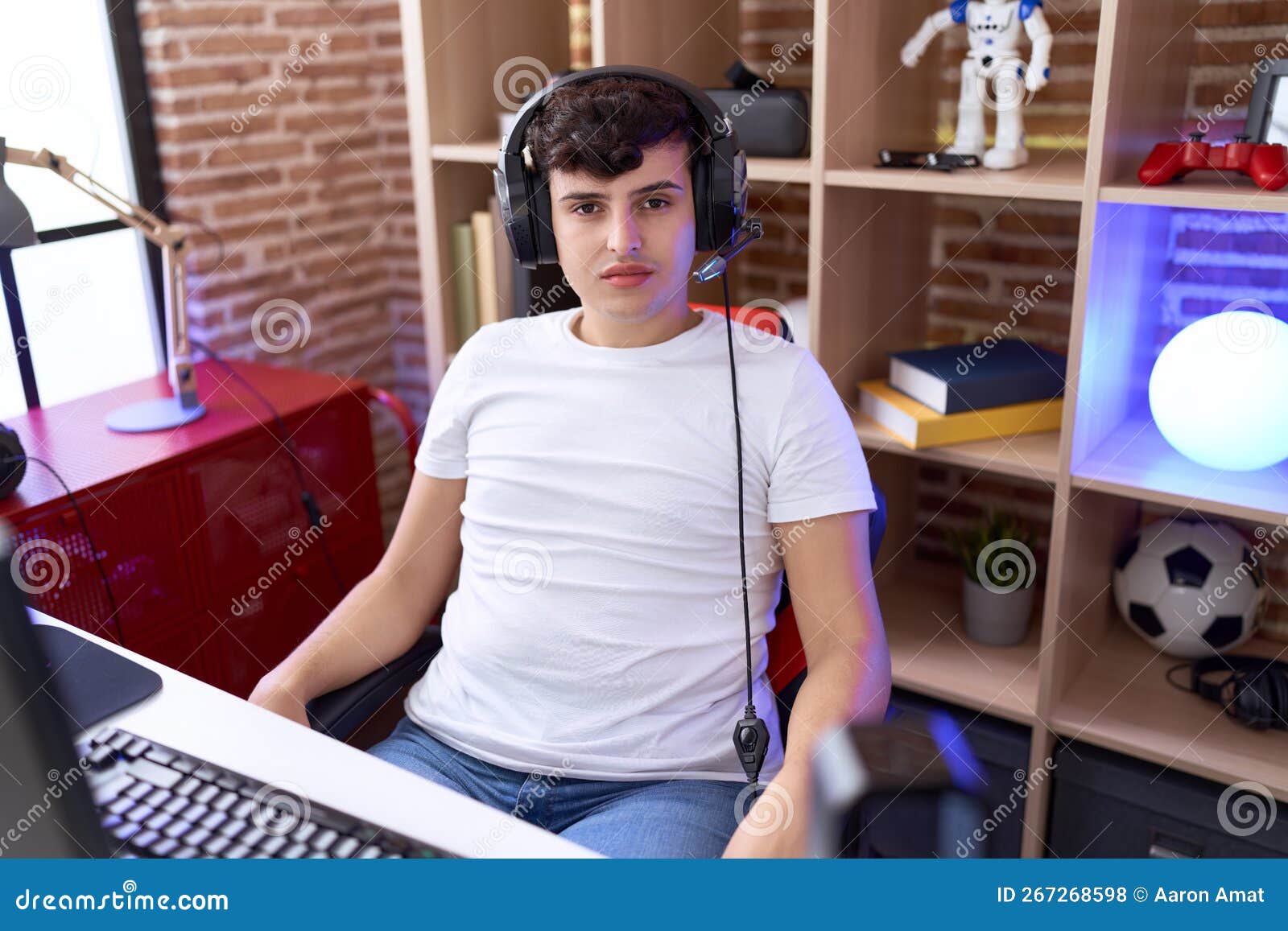 Non Binary Man Streamer Sitting on Table with Relaxed Expression at ...