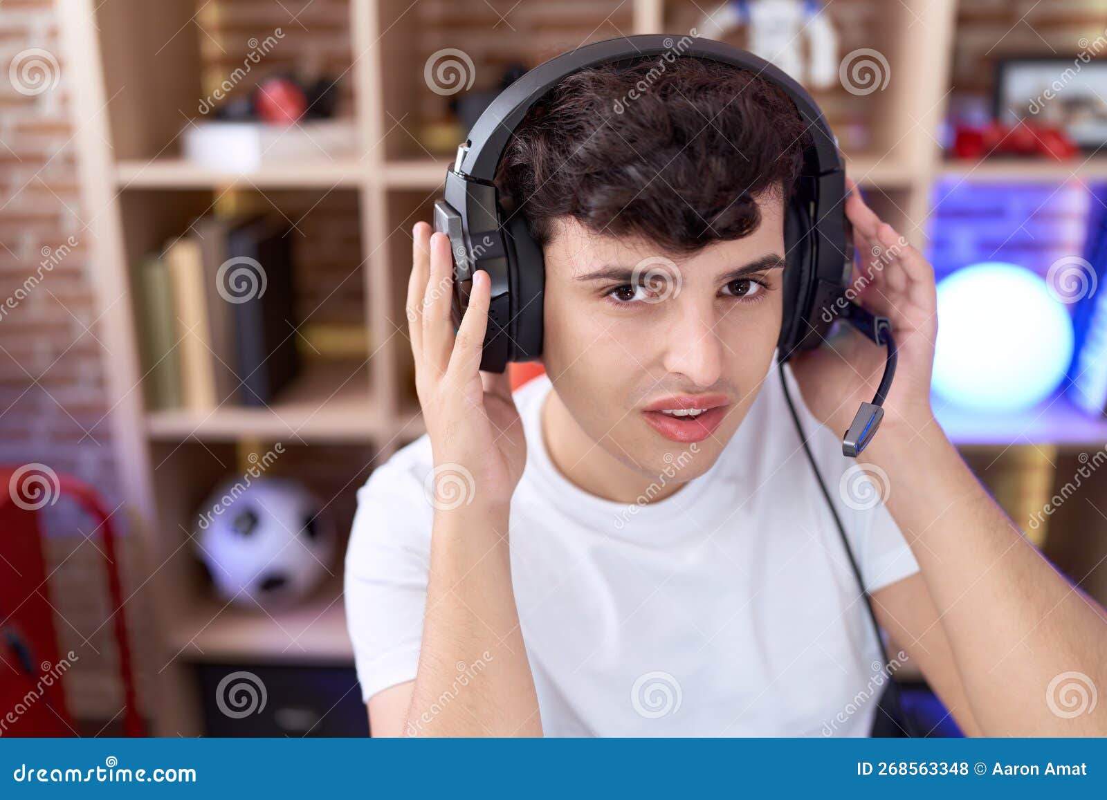 Non Binary Man Streamer Sitting on Table with Relaxed Expression at ...