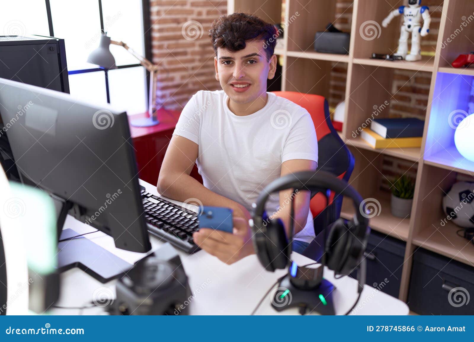 Non Binary Man Streamer Using Computer and Smartphone at Gaming Room ...
