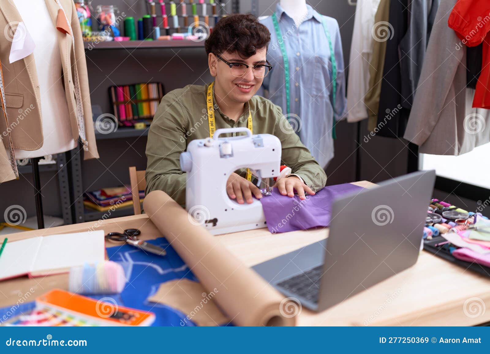 Non Binary Man Tailor Using Sewing Machine and Laptop at Atelier Stock ... Non Binary Man Tailor Using Sewing Machine and Laptop at Atelier Stock ...