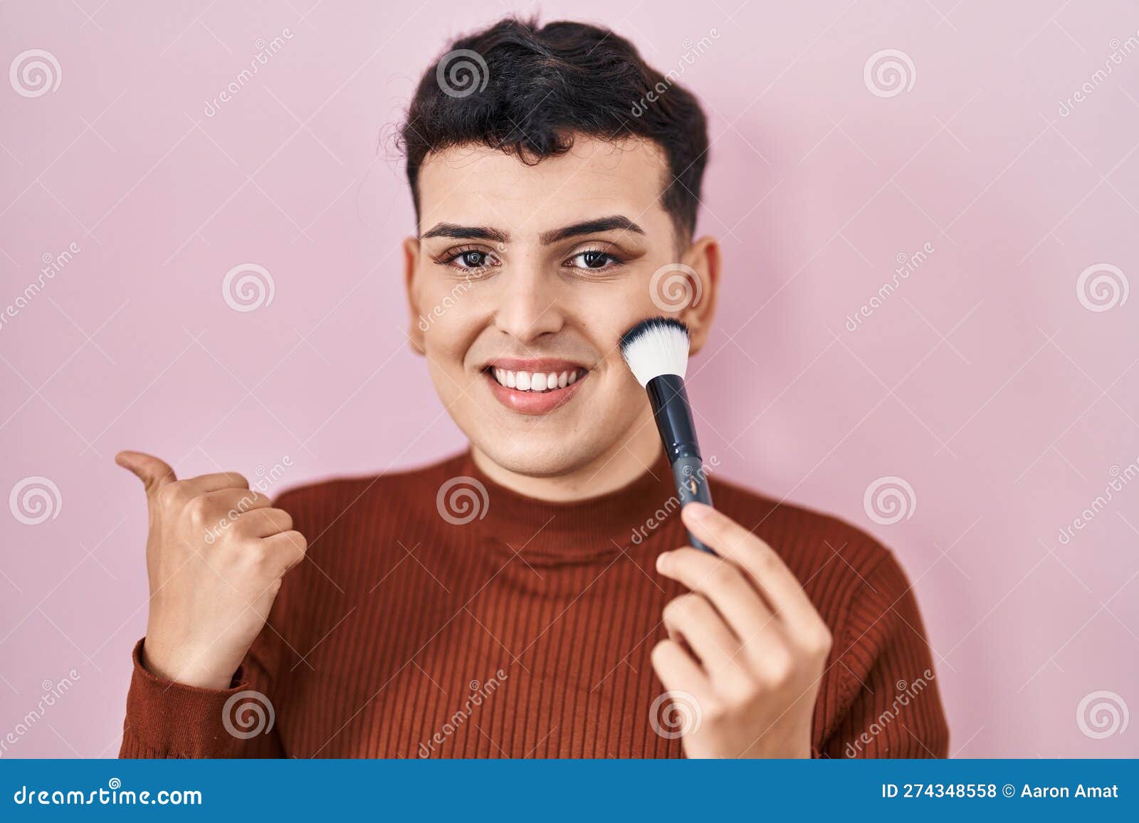Non Binary Person Applying Make Up Pointing Thumb Up To the Side ...