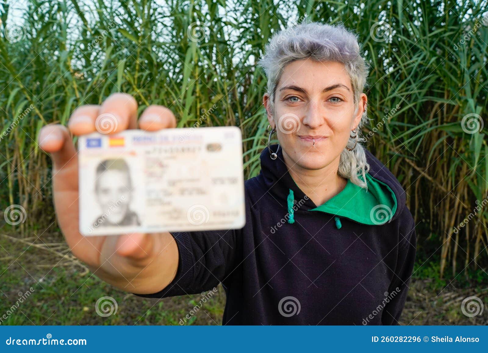 Non-binary Person Looking at Camera with ID in Hand. Non-binary ...