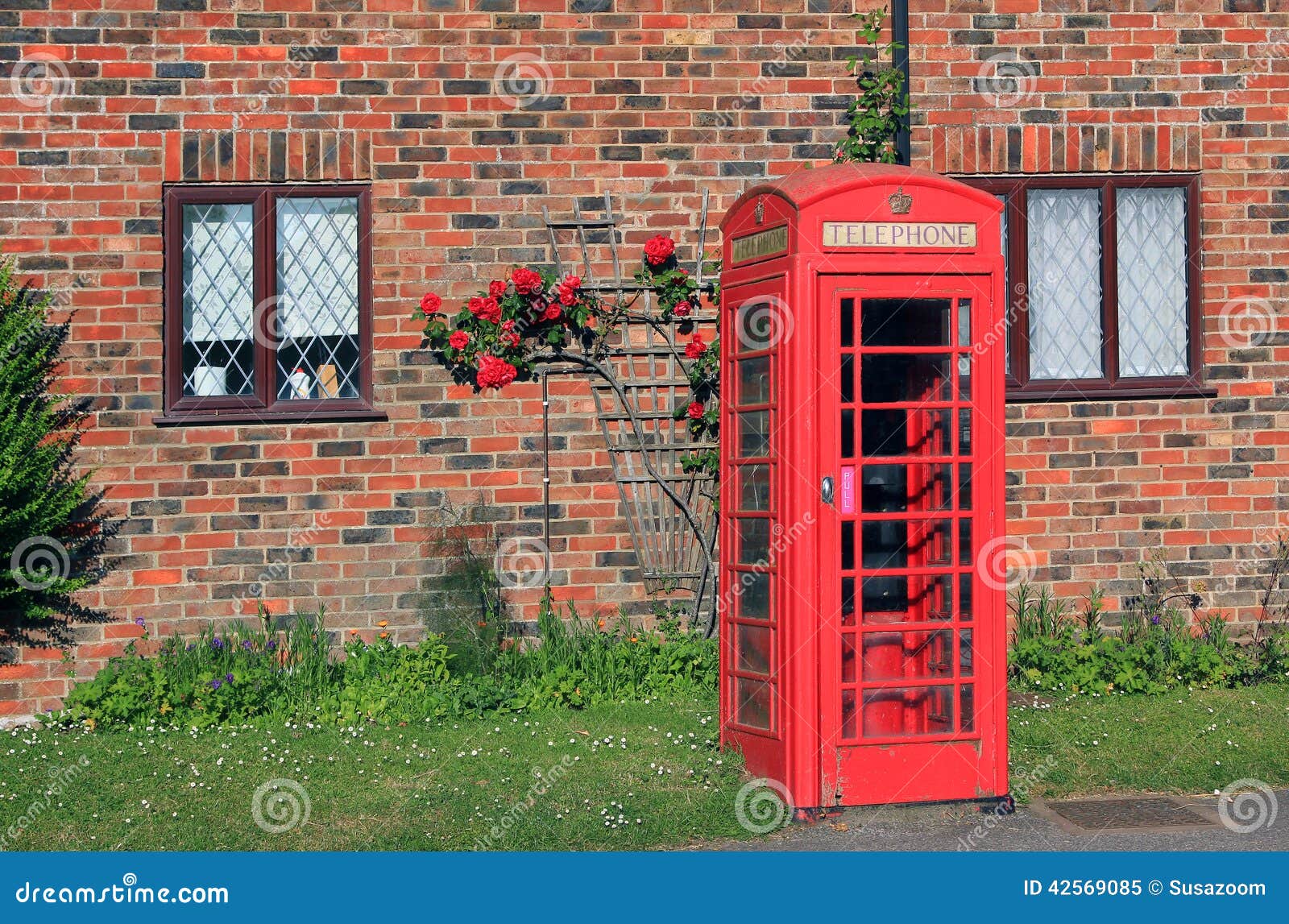 Nostalgic Phone Box in Front of Red Brick Wall with Rambler Rose Stock ...