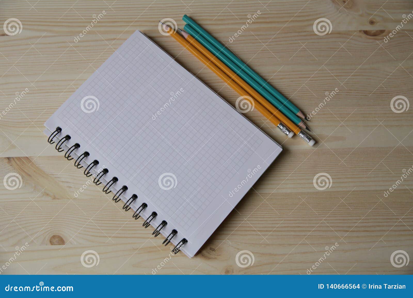 Notebook and Four Pencils Next To the Notebook on a Light Wooden Table ...