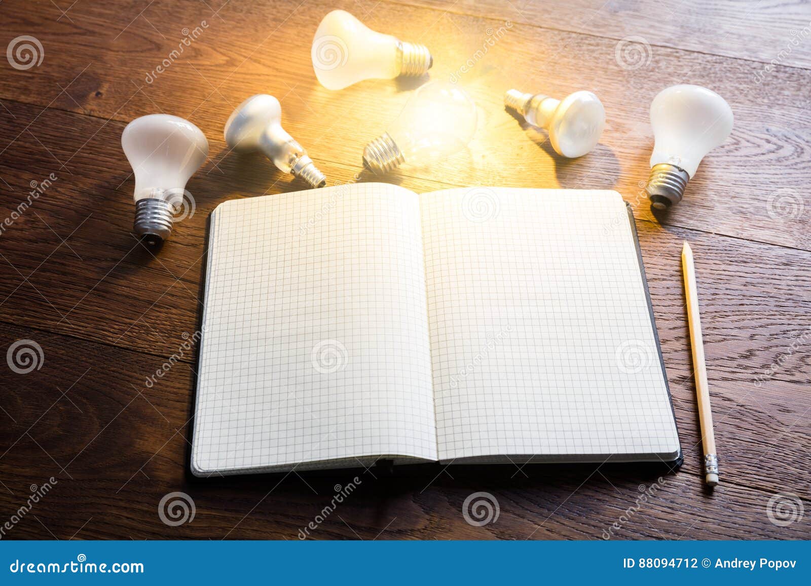 Notebook with Glowing Light Bulbs on Wooden Desk Stock Photo - Image of ...