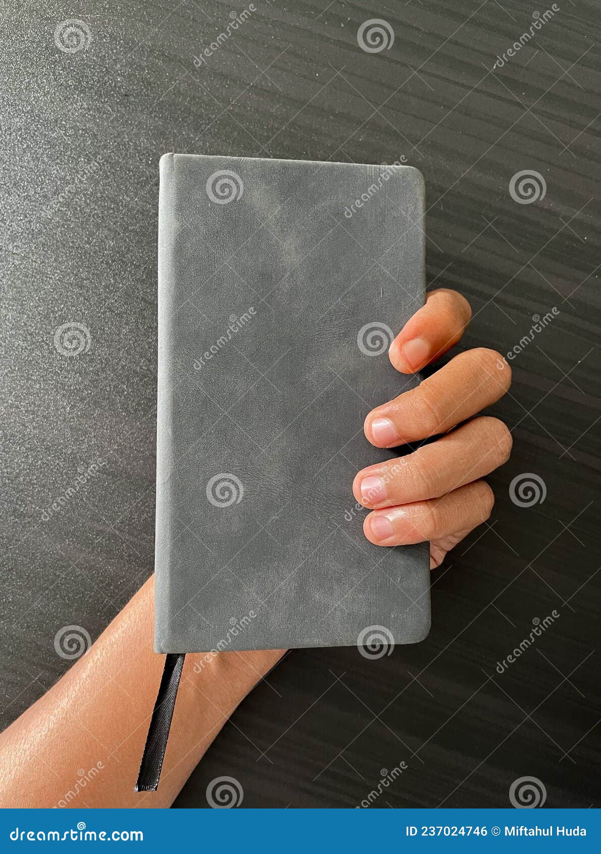 Notebook in Hand. a Small Grey Notebook To Record Everything Stock ...