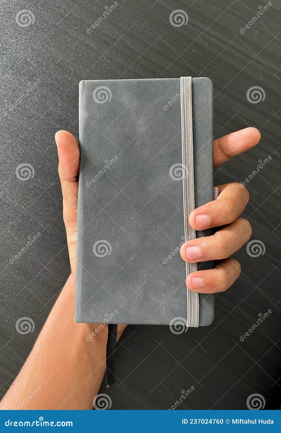 Notebook in Hand. a Small Grey Notebook To Record Everything Stock ...