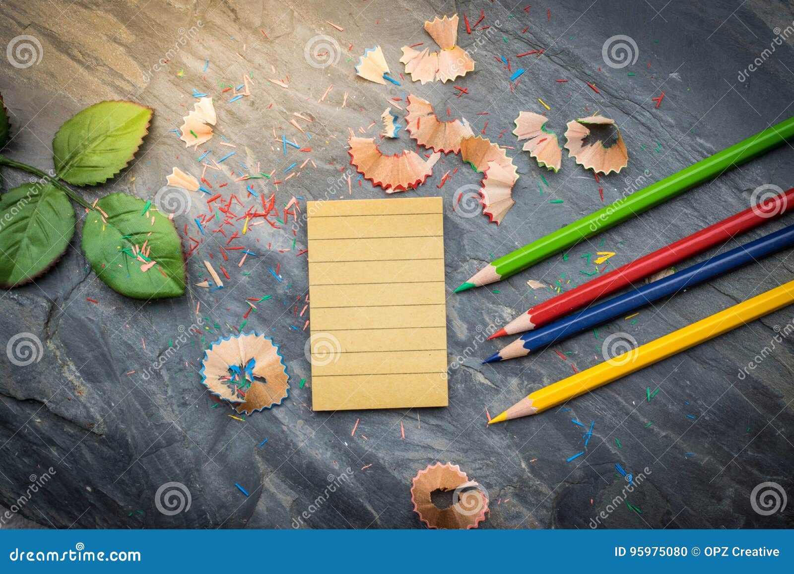 A Notebook for Notes with Crayons and Pencils. Pencil Sharpener Placed ...