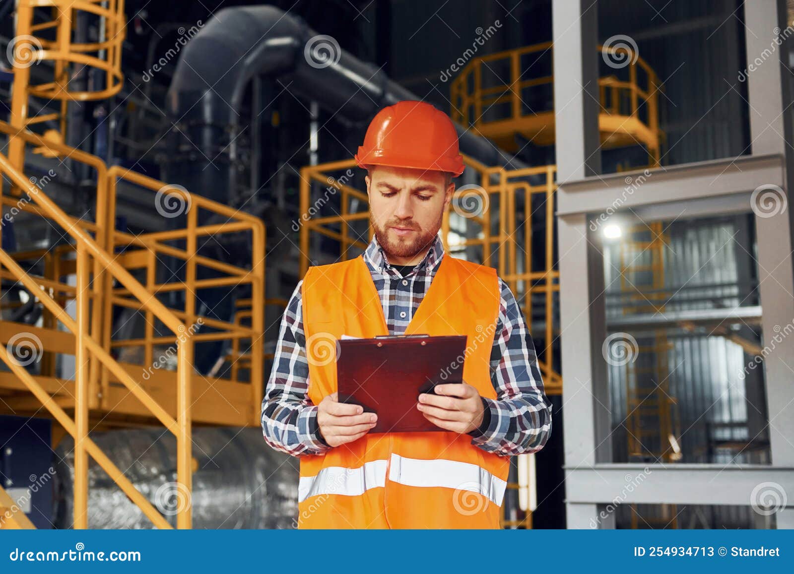 With Notepad. Construction Worker in Uniform is in the Factory Stock ...