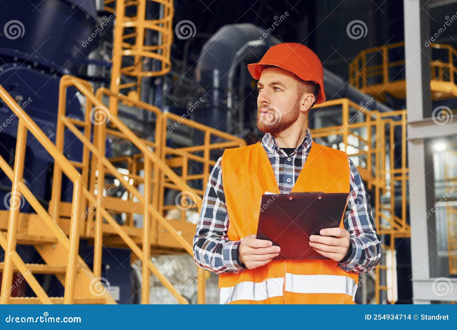 With Notepad. Construction Worker in Uniform is in the Factory Stock ...