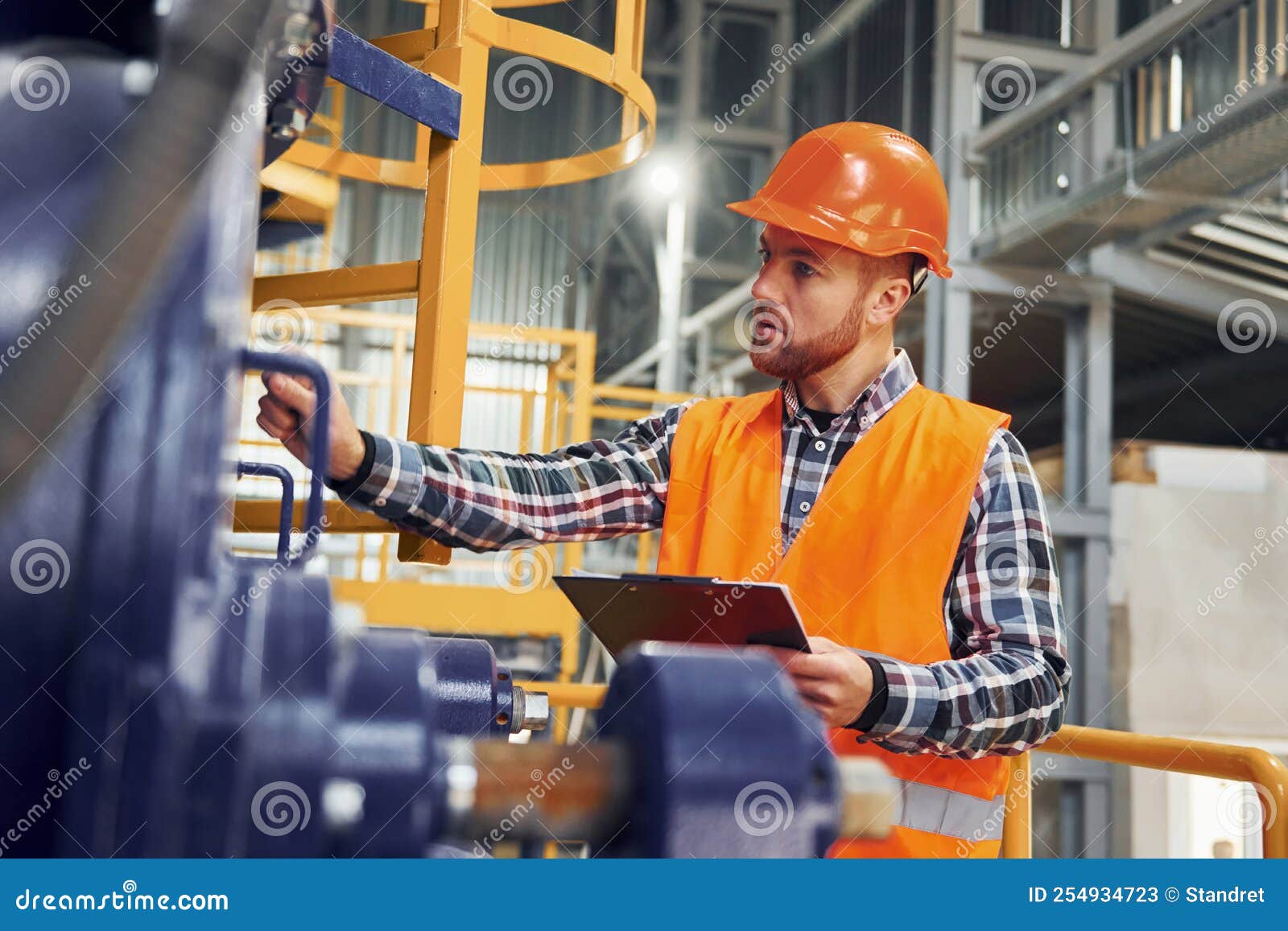 With Notepad. Construction Worker in Uniform is in the Factory Stock ...