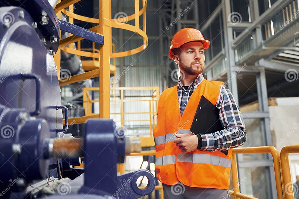 With Notepad. Construction Worker in Uniform is in the Factory Stock ...