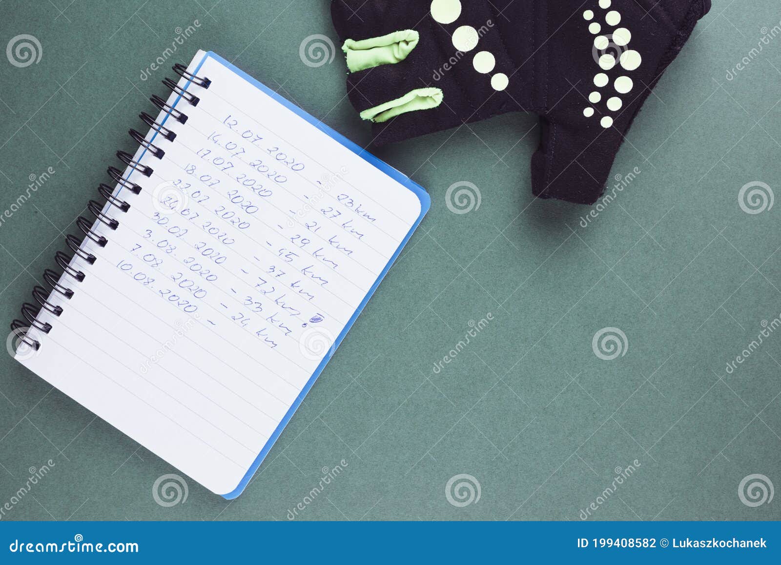 A Notepad with Dates and Distance Cycled on Natural Green Background ...
