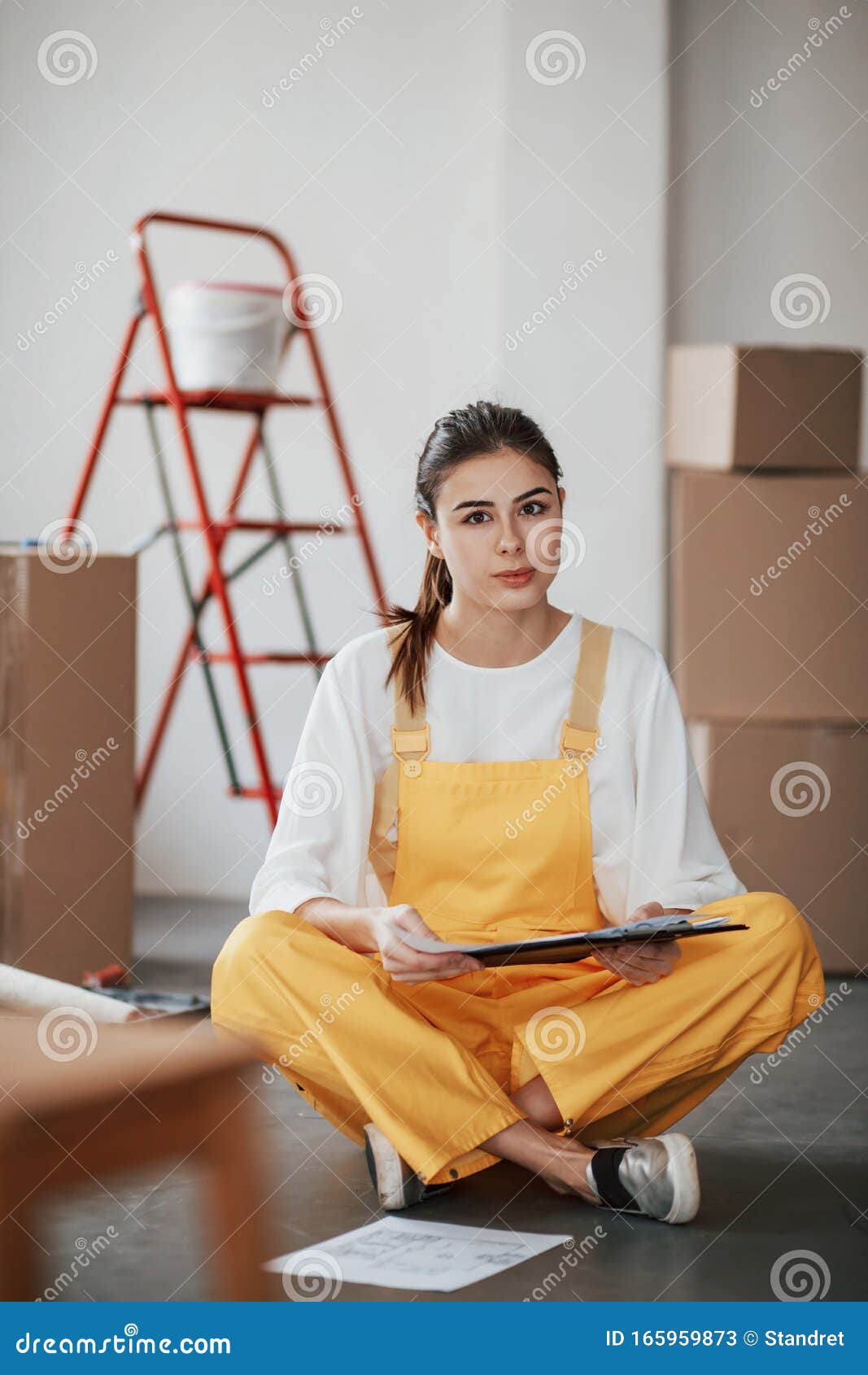 Notepad is in Hands. Young Brunette in the Room with White Walls and ...