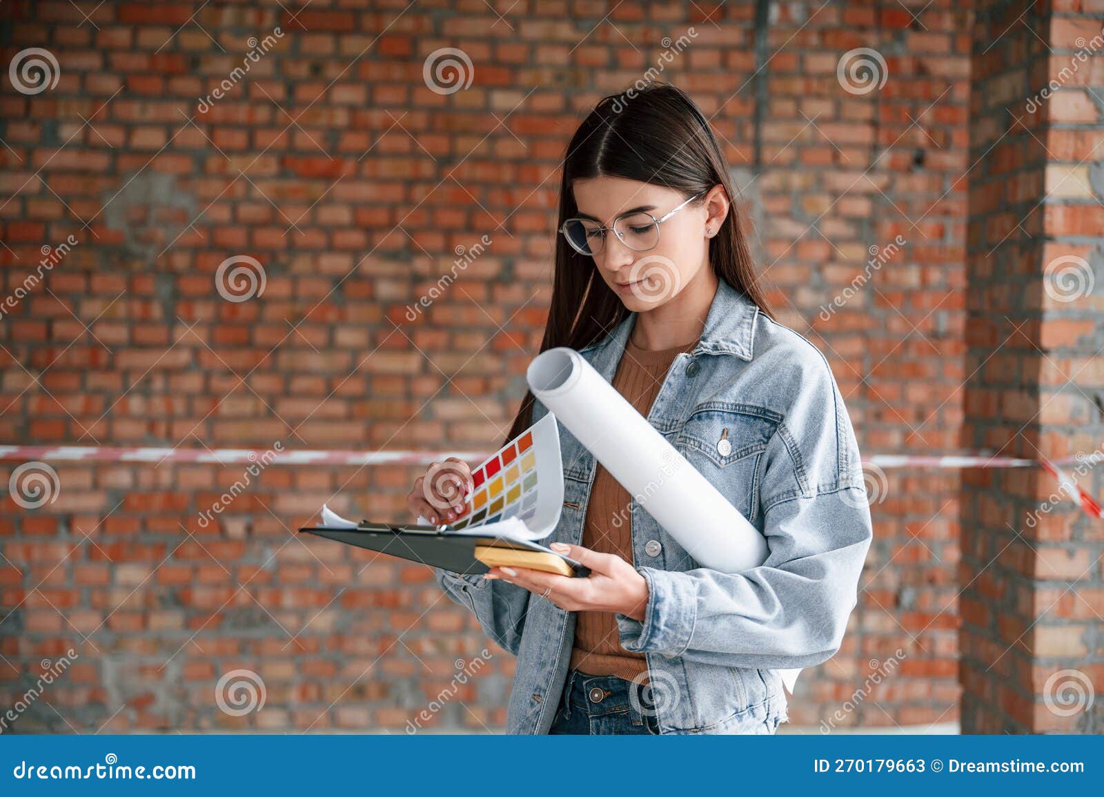 Notepad in Hands. Young Woman is Standing in the Unfinished Building on ...
